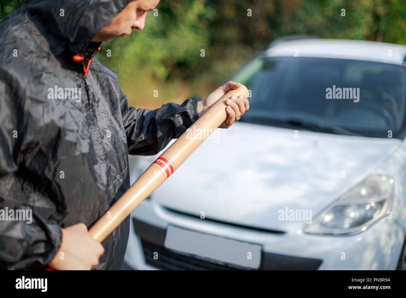 The aggressive person with the baseball bat in front of the car Stock ...