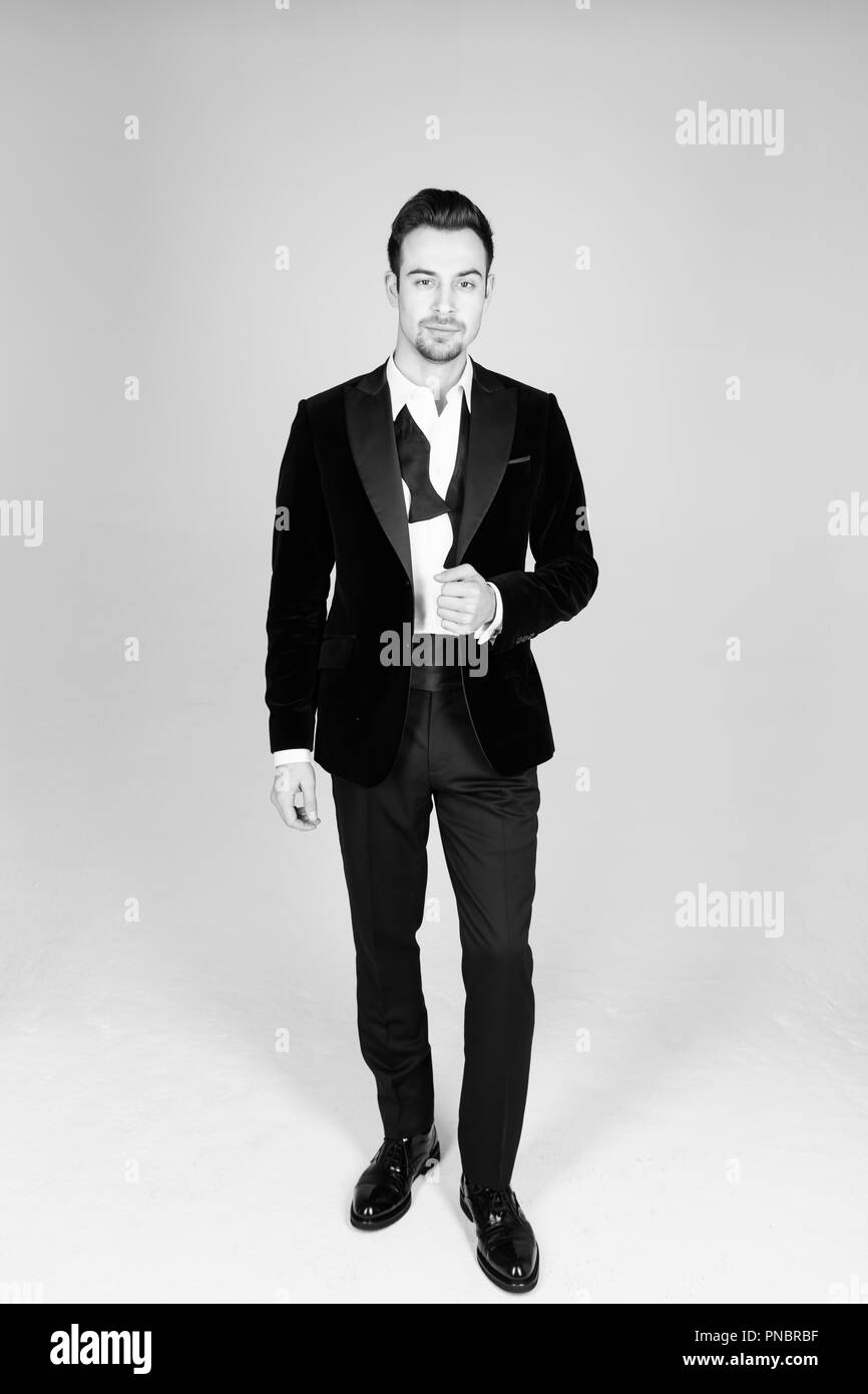 Portrait of a young handsome man in a suit, standing and looking at the ...