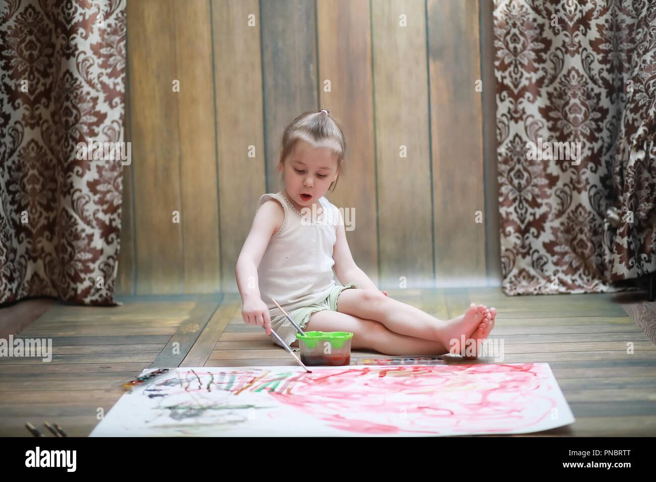 Little children paint on a large sheet of paper Stock Photo - Alamy