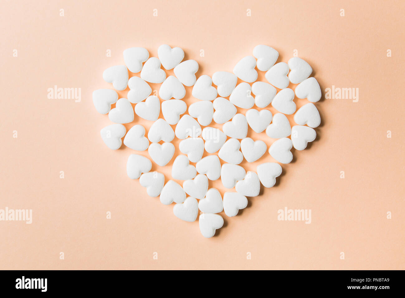 Heart-shaped pills on a beige background. Medical content Stock Photo ...