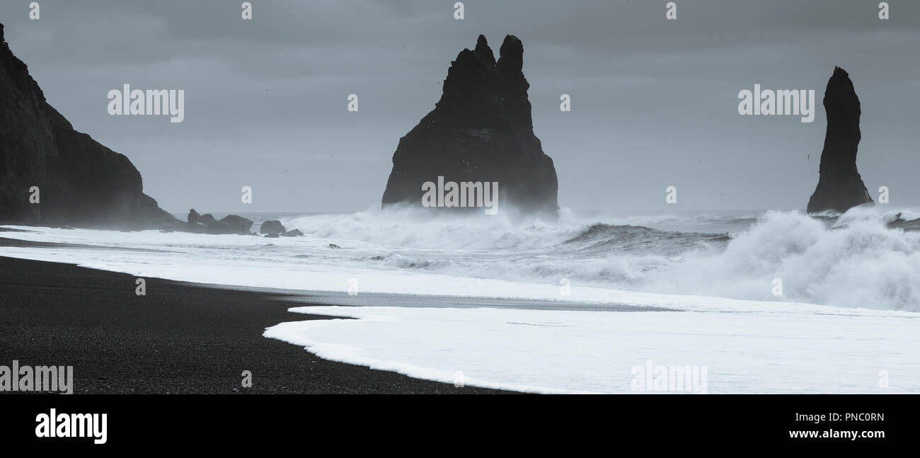 Reynisdrangar basalt sea stacks (troll rocks) and black volcanic sand ...