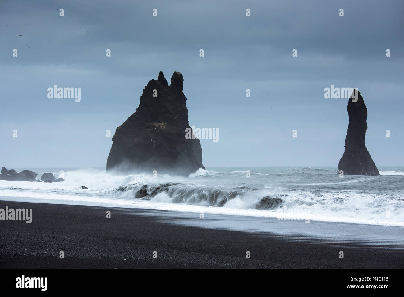 Reynisdrangar basalt sea stacks (troll rocks) and black volcanic sand ...
