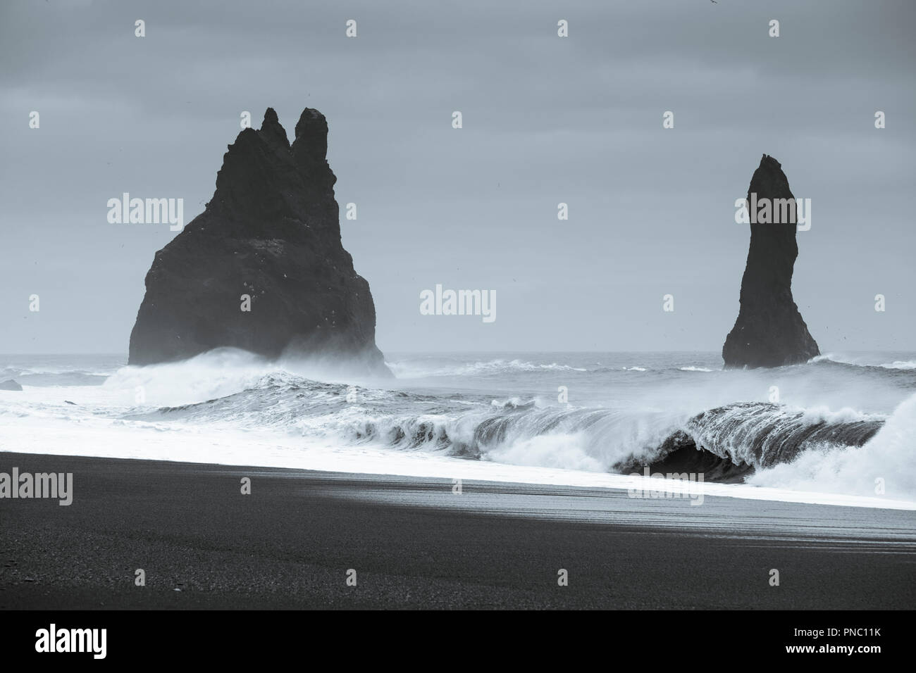 Reynisdrangar basalt sea stacks (troll rocks) and black volcanic sand ...