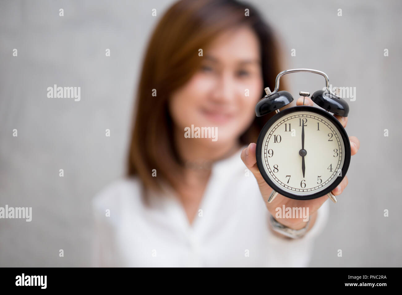 Asian women show clock times at 6 o'clock, It's time to do something ...