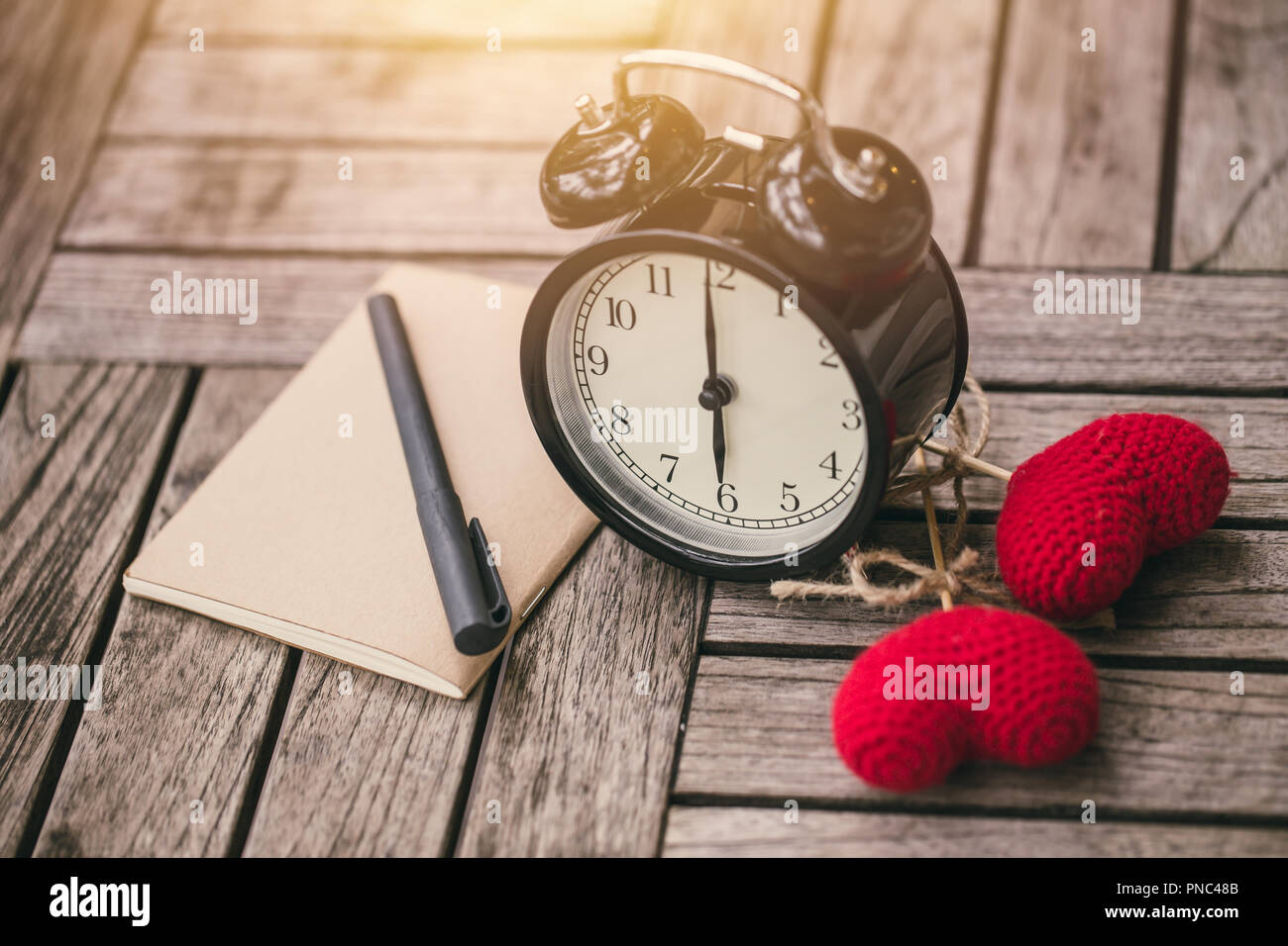 retro clock time at 6 o'clock with notebook or memo on wood table ...