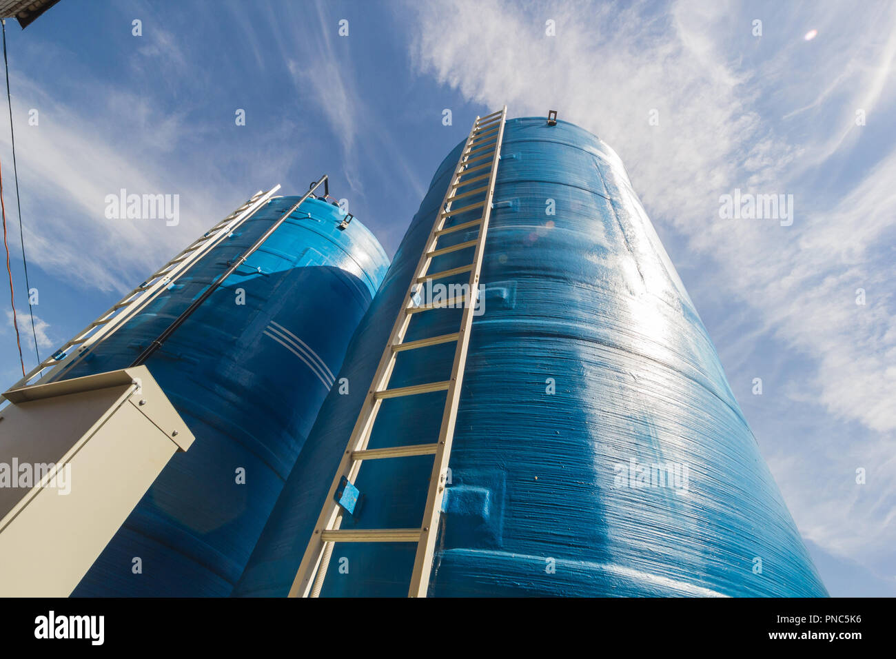 Blue water tower with a white staircase and a black hose Stock Photo ...