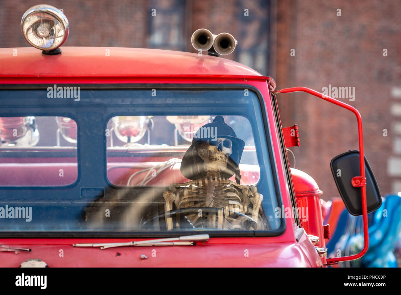 At the old fire truck, a human skeleton with a fireman helmet is placed ...