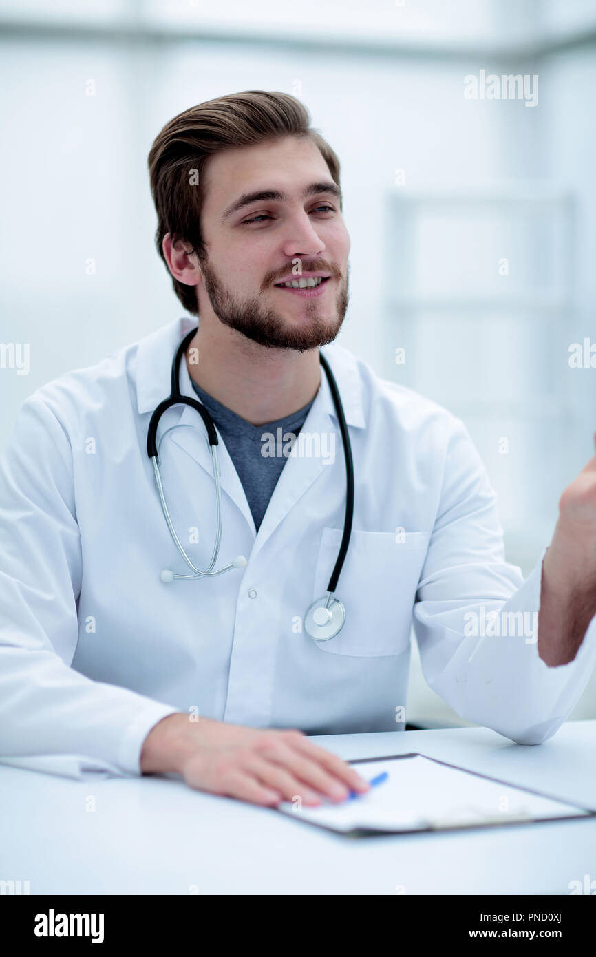 Doctor sitting behind a desk hi-res stock photography and images - Alamy