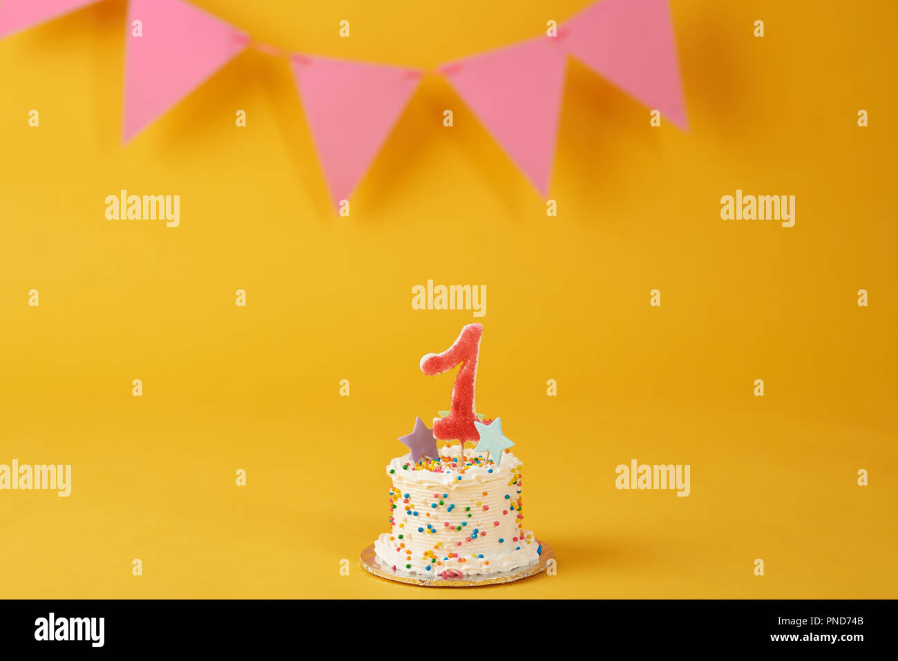 One white cake for kid isolated on yellow background Stock Photo - Alamy