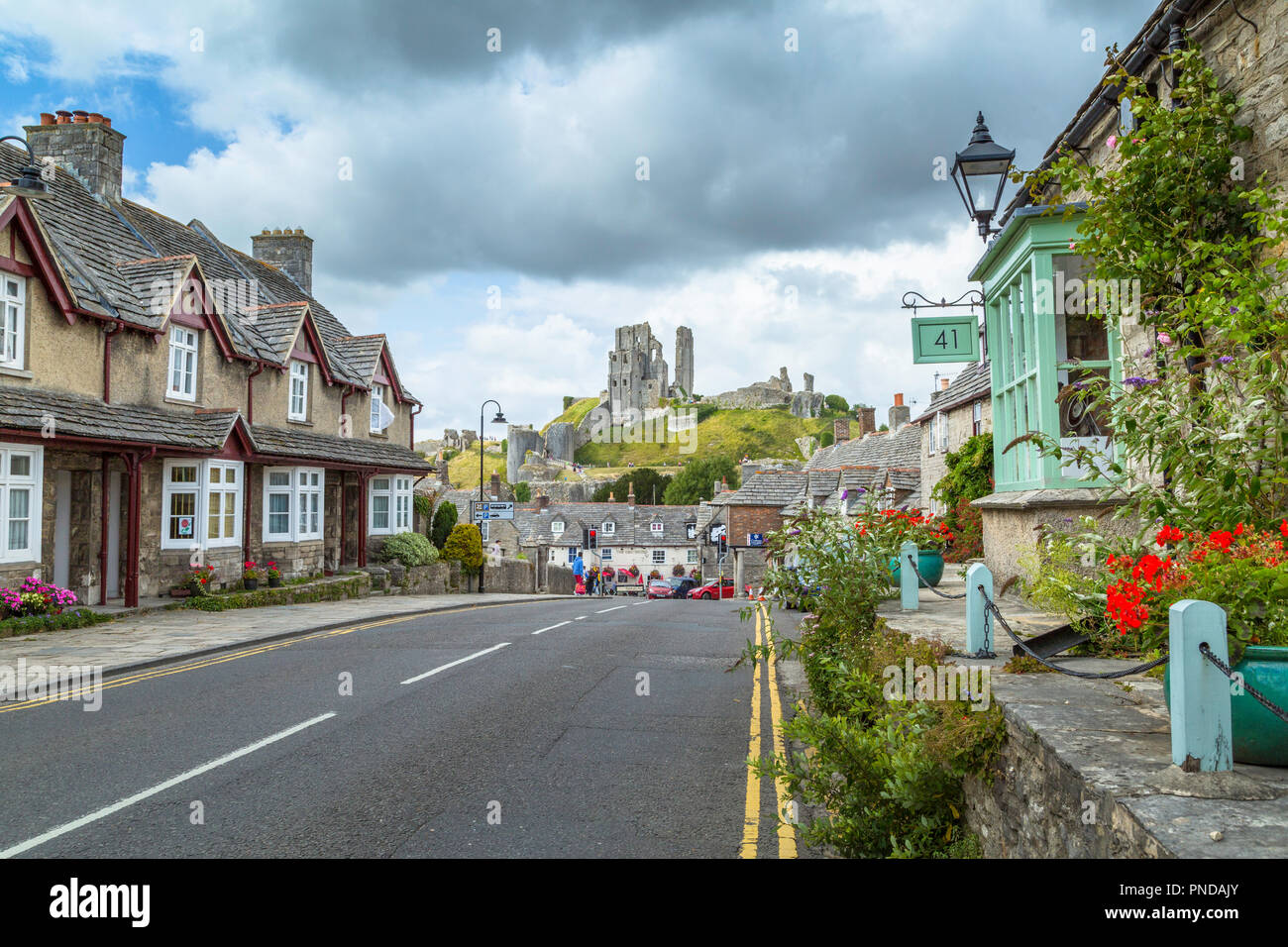 The village of Corfe Castle with the castle itself on the hill beyond ...