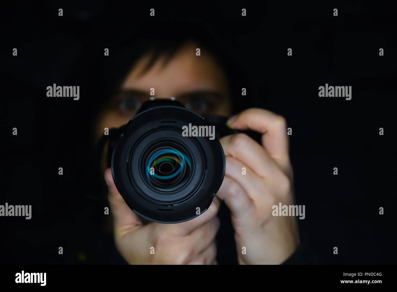 the photographer looks at the camera on a black background Stock Photo ...