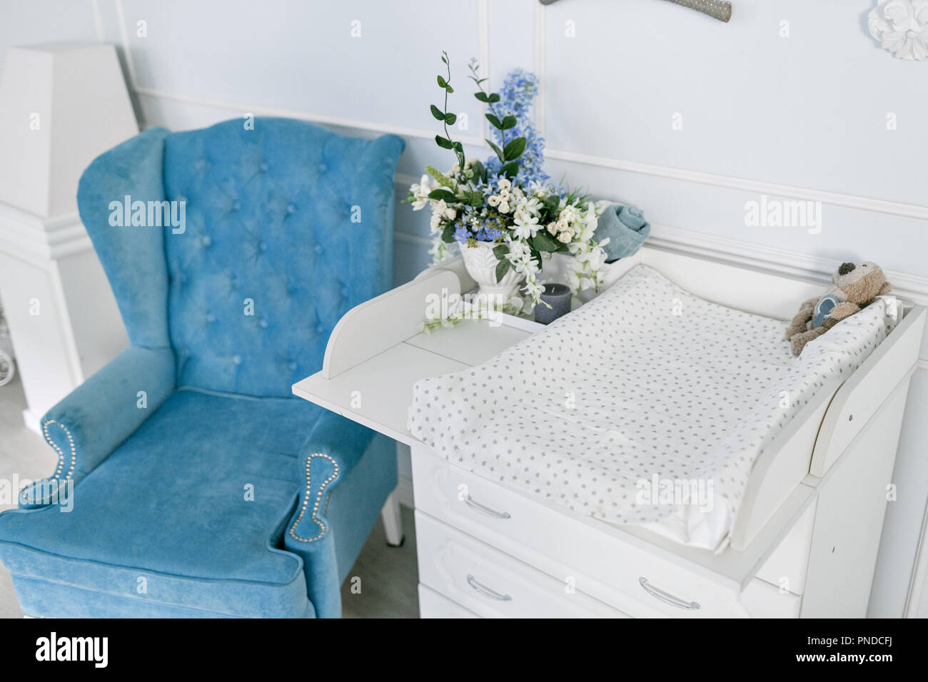 Blue chair and changing table for infants. interior of a spacious ...