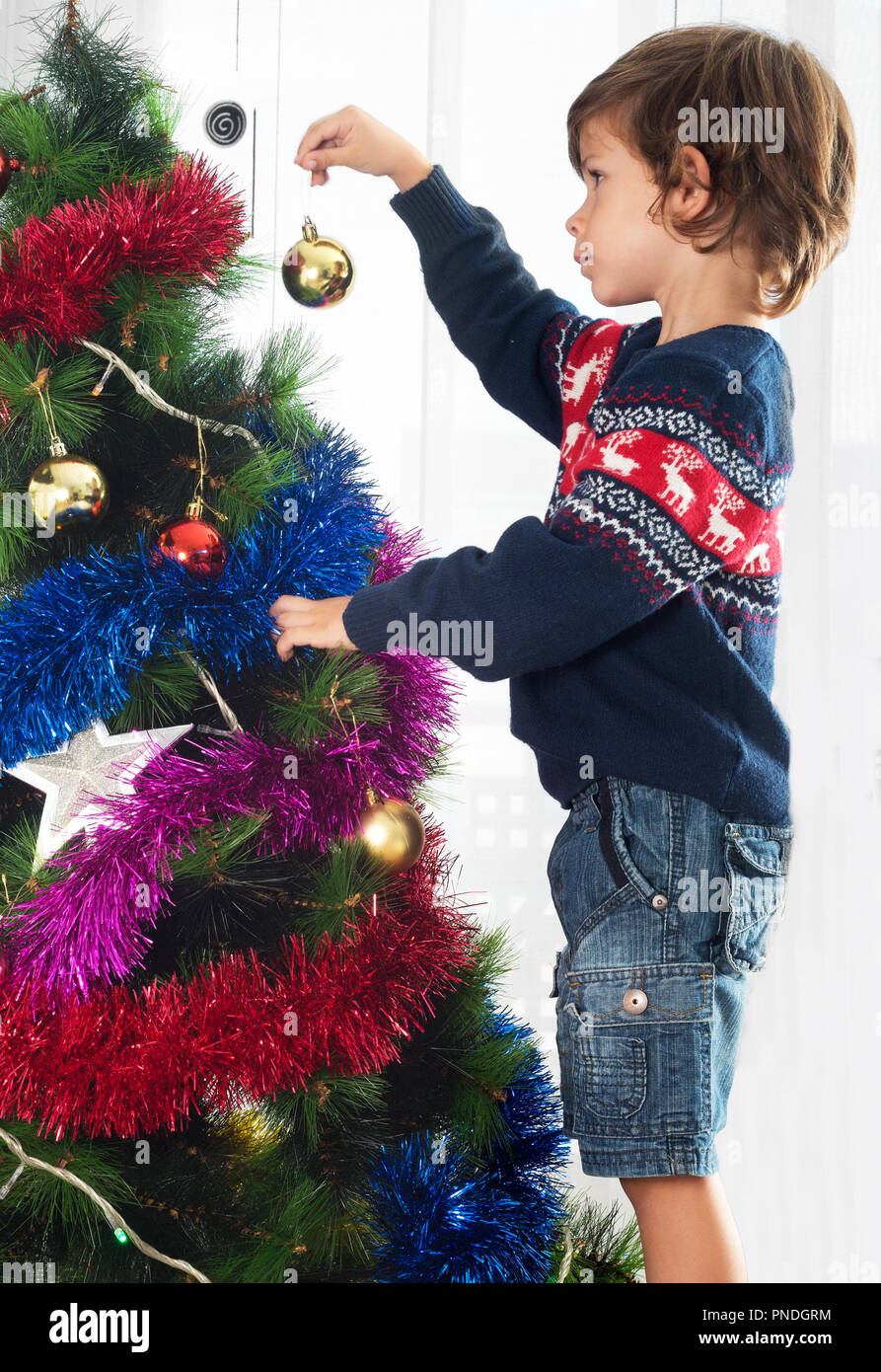 Boy decorating Christmas tree Stock Photo - Alamy