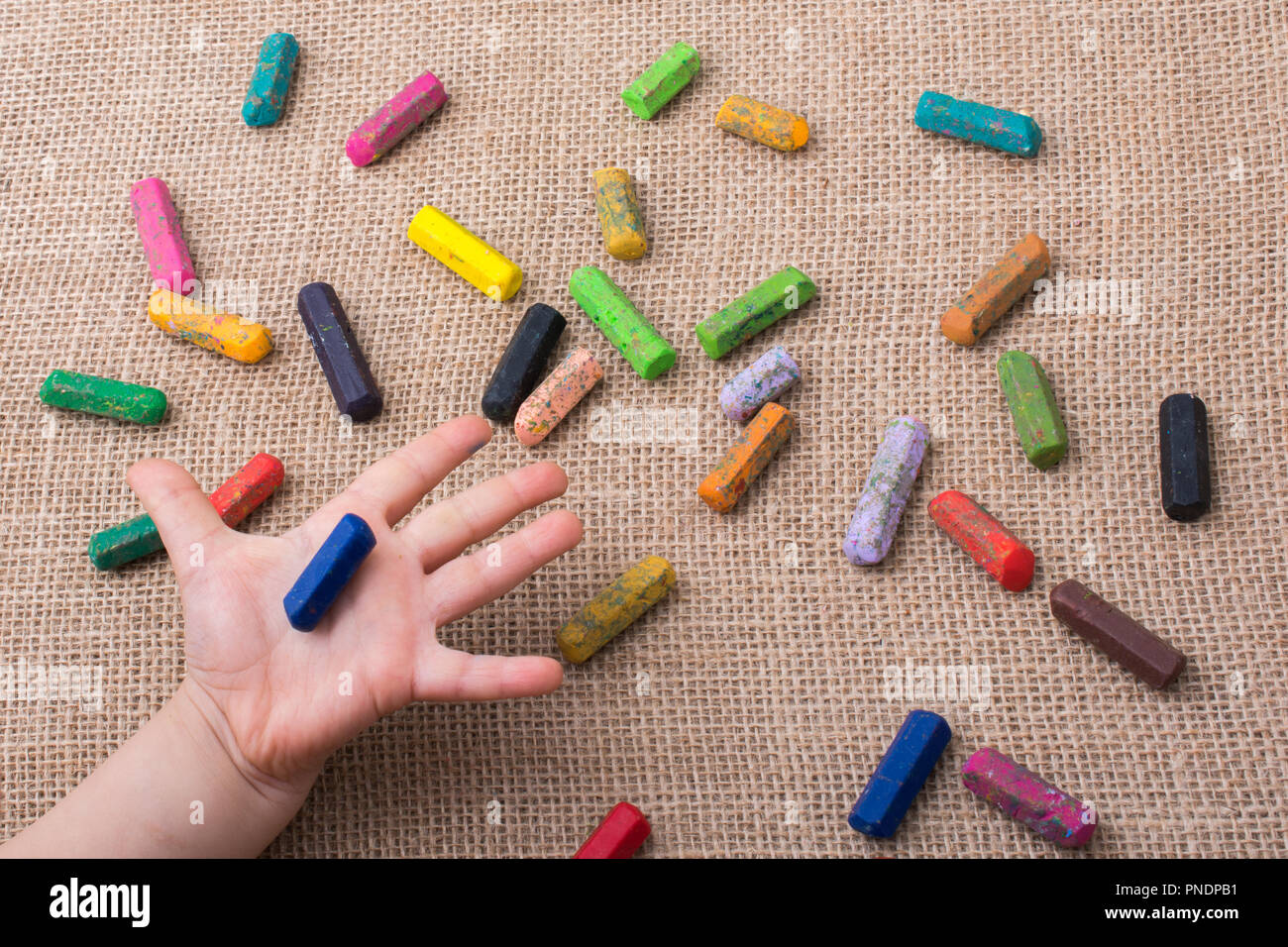 Used color crayons and a toddlers hand holding one Stock Photo - Alamy