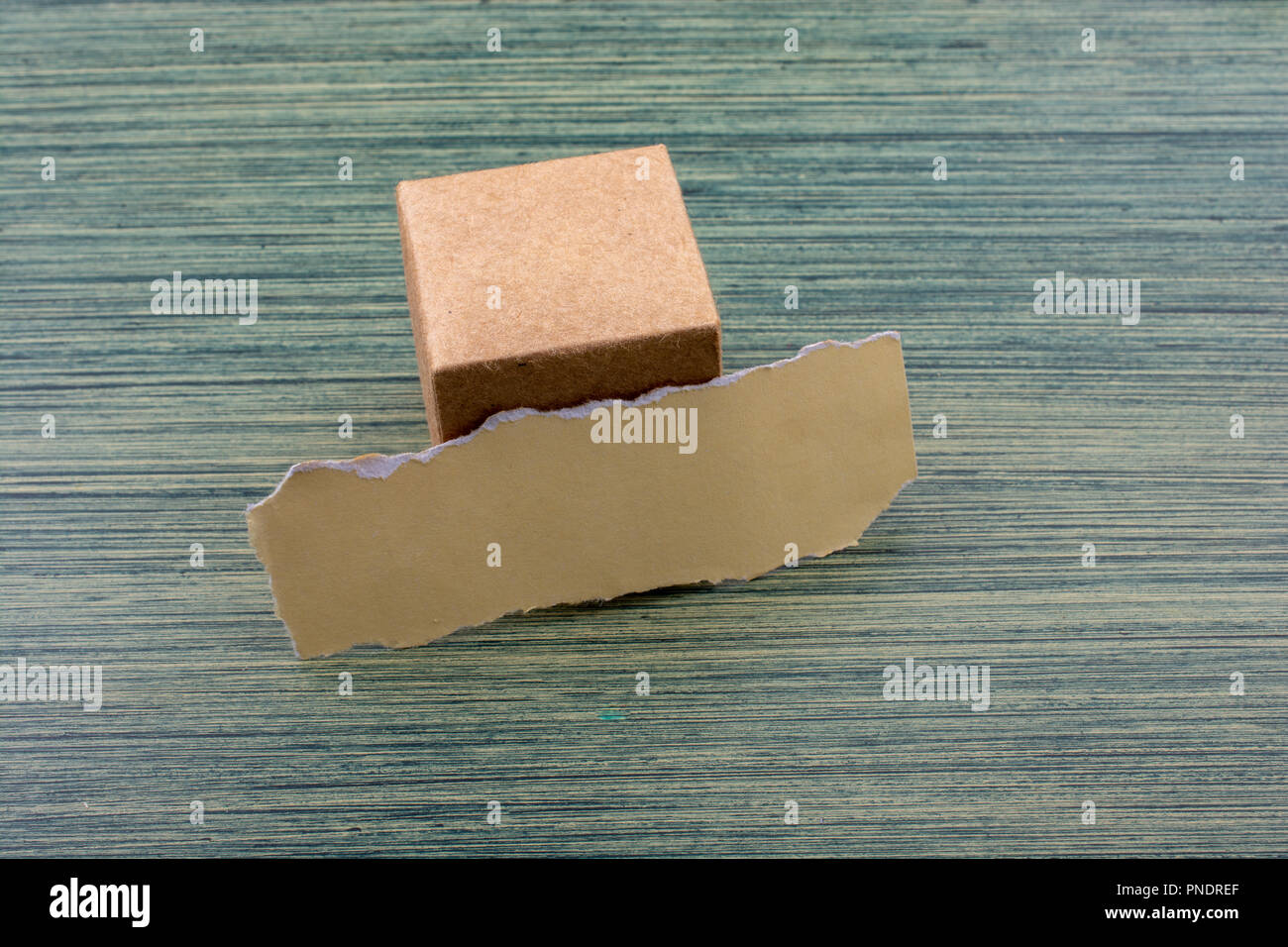 Torn paper and a paper box cube on wooden texture Stock Photo - Alamy