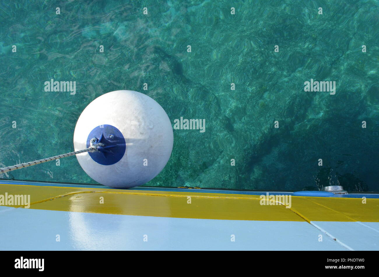 buoy of a small boat in the blue turquoise and cyan colored water in ...