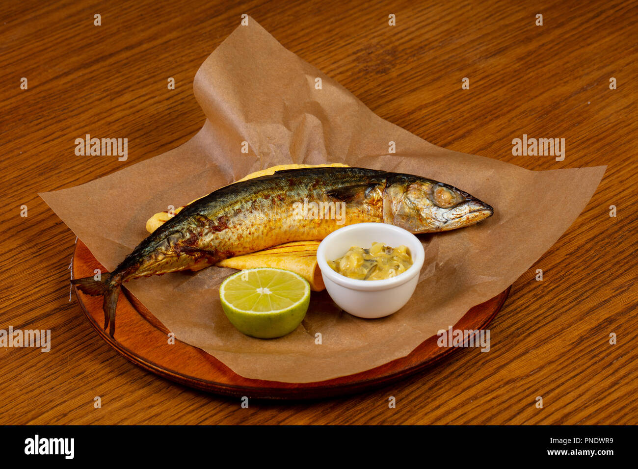 Smoked scomber fish with sauce and lime Stock Photo - Alamy