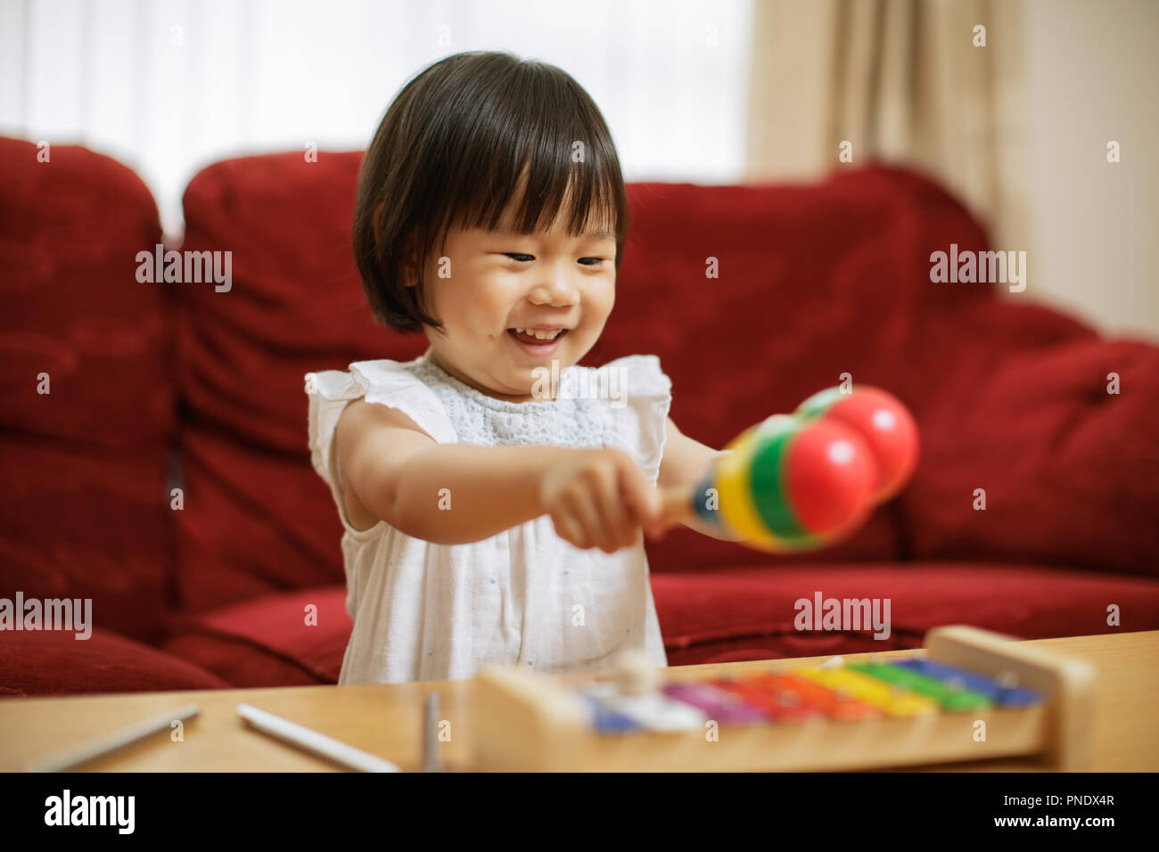 baby girl play maracas at home Stock Photo - Alamy