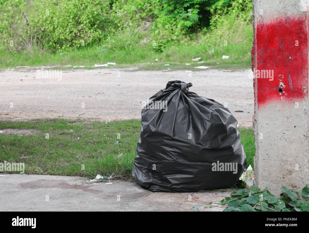 black garbage bag roadside in the city Stock Photo - Alamy