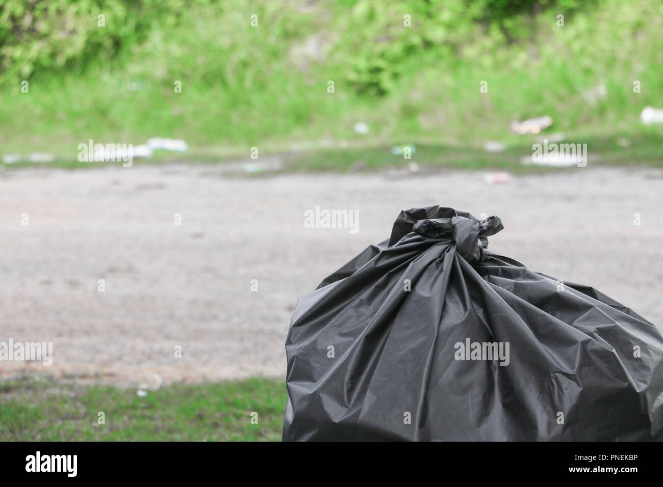 black garbage bag roadside in the city Stock Photo - Alamy