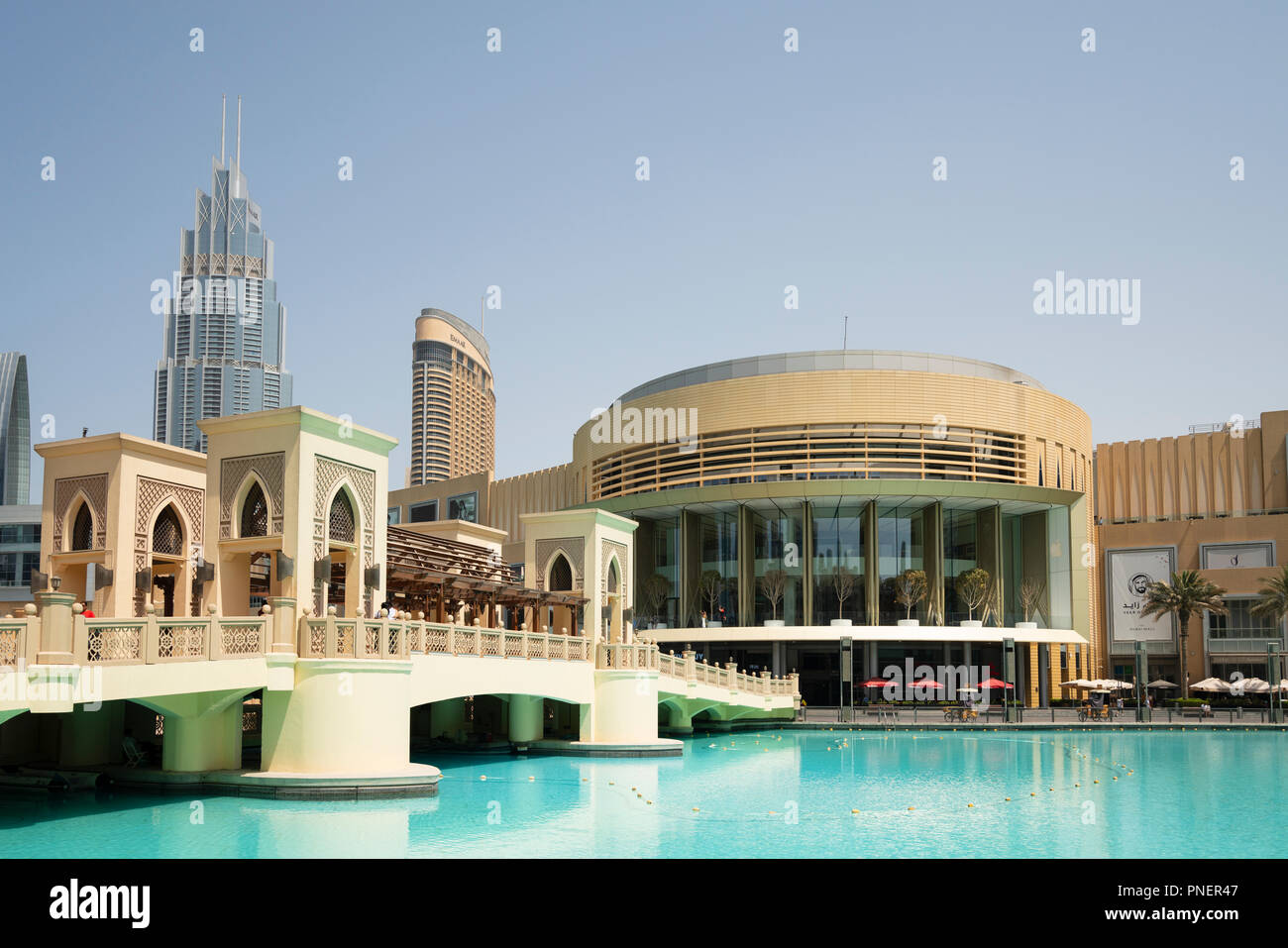 View of exterior of Dubai Mall with ornate footbridge across pond in ...