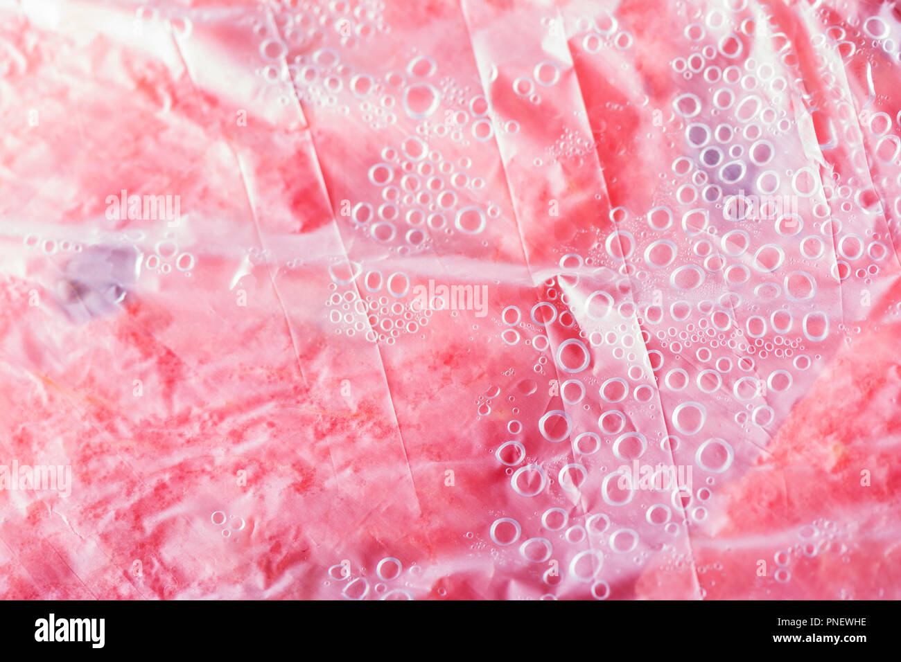 Background texture of a fresh juicy pink watermelon under plastic cover ...