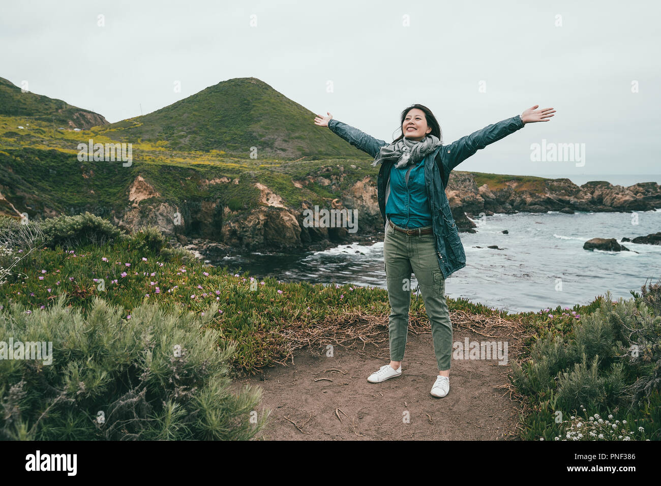 travel woman opening her arms to embrace the nature standing on the ...