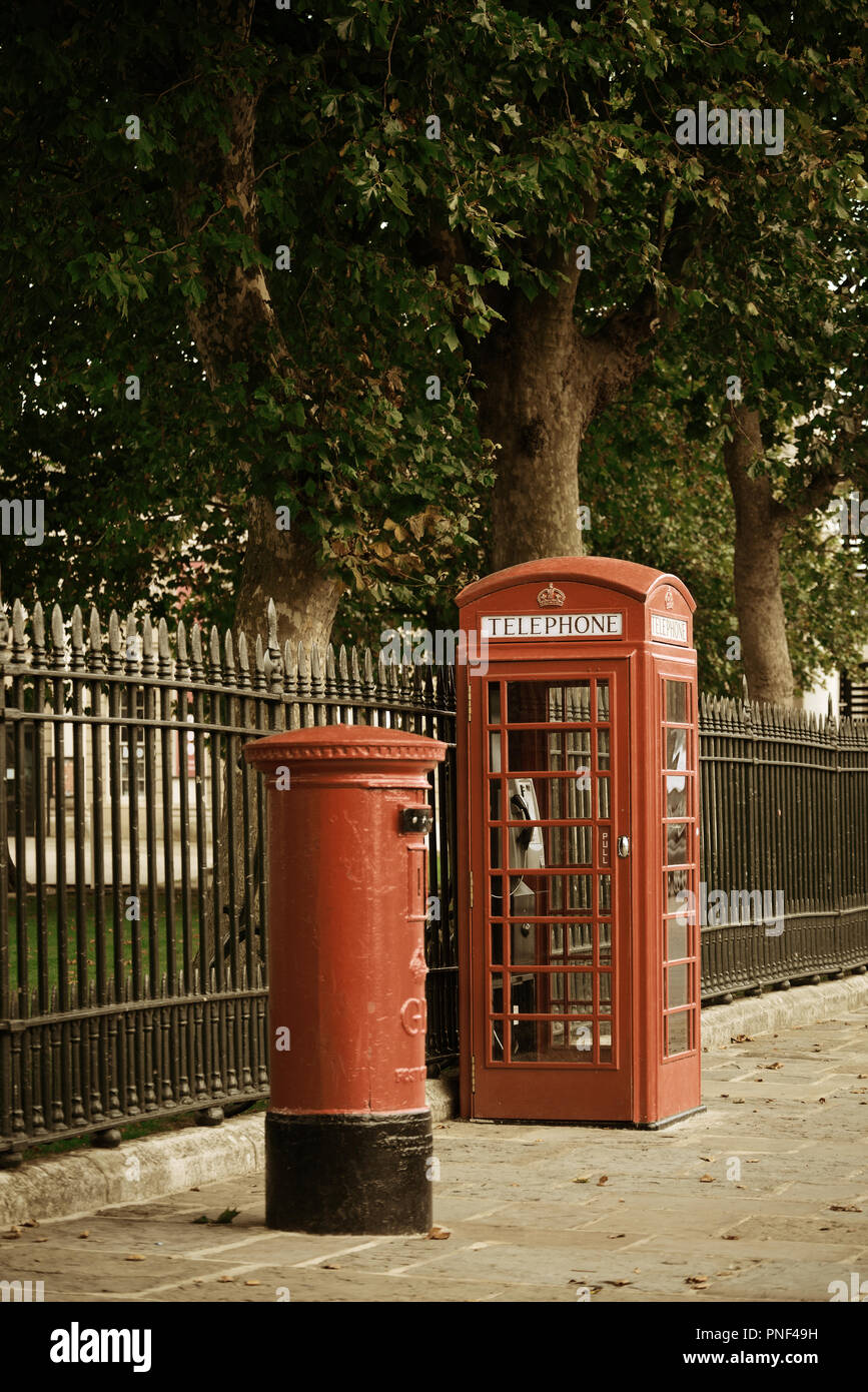Red telephone and post box in street with historical architecture in ...
