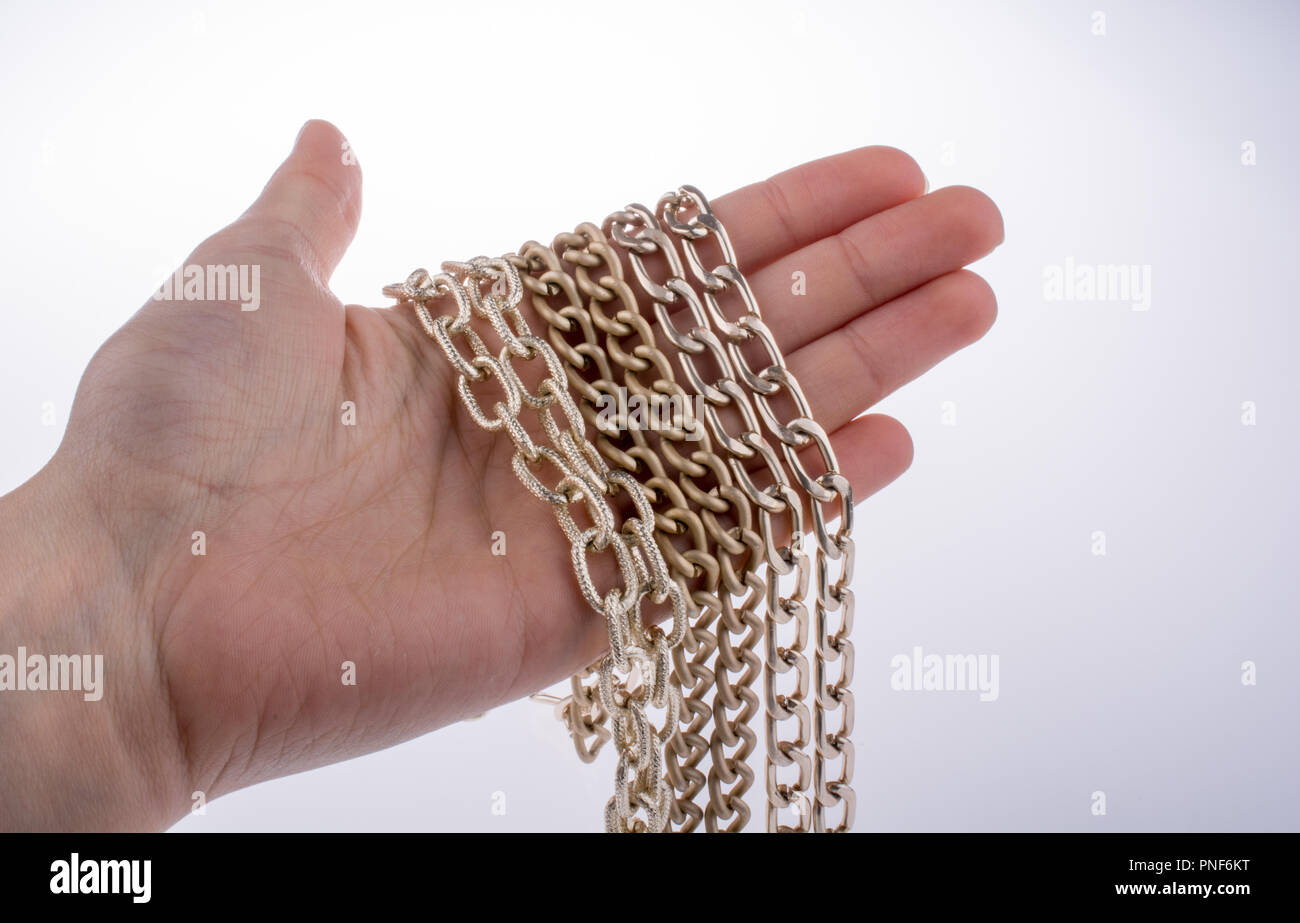 Gold color chain in hand on white background Stock Photo - Alamy