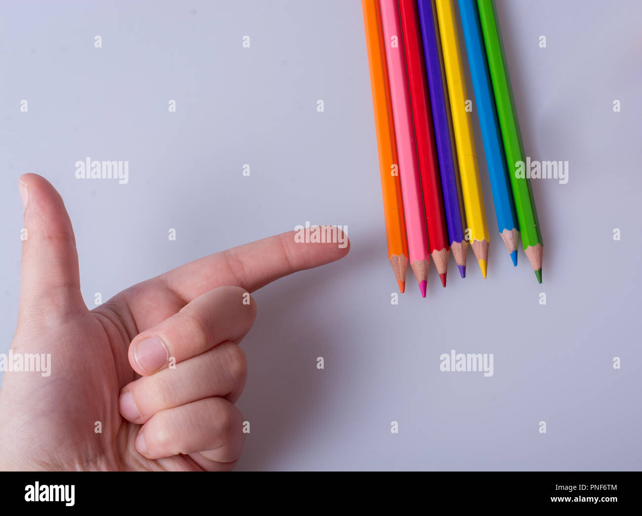 Hand holding color Pencils placed on a white background Stock Photo - Alamy
