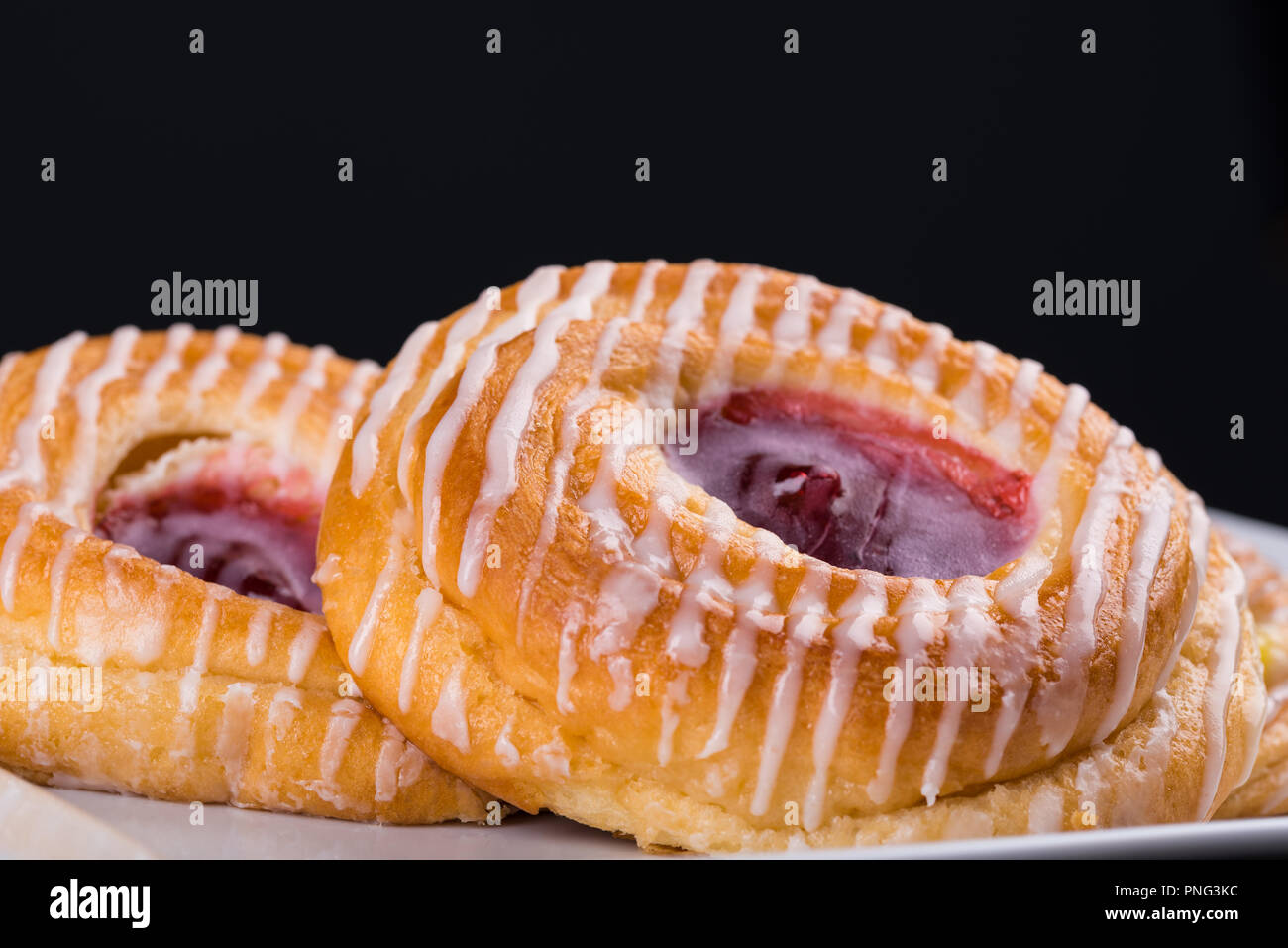 Strawberry Danish pastry against a dark background with copy space ...