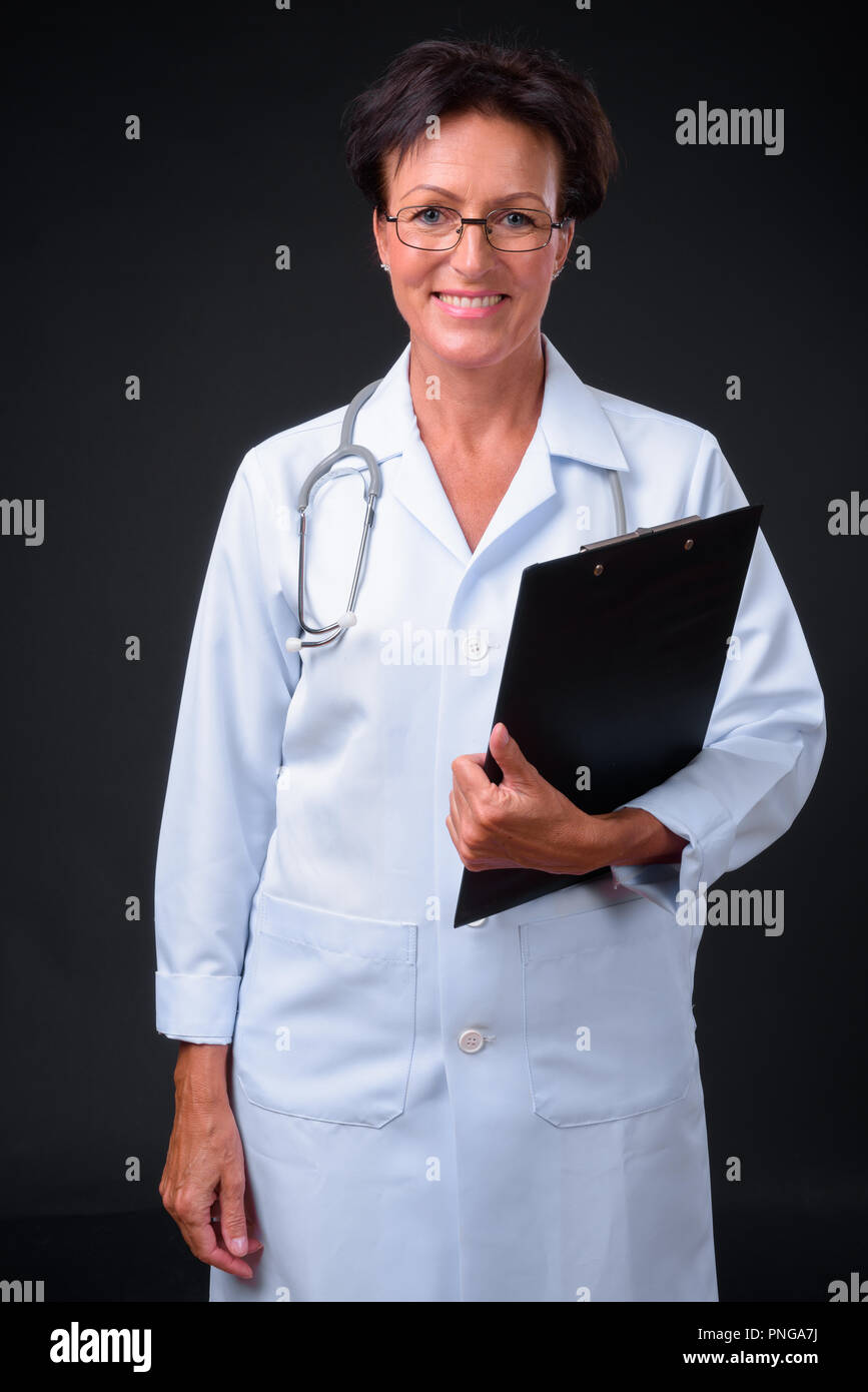 Mature beautiful woman doctor with short hair against black back Stock ...