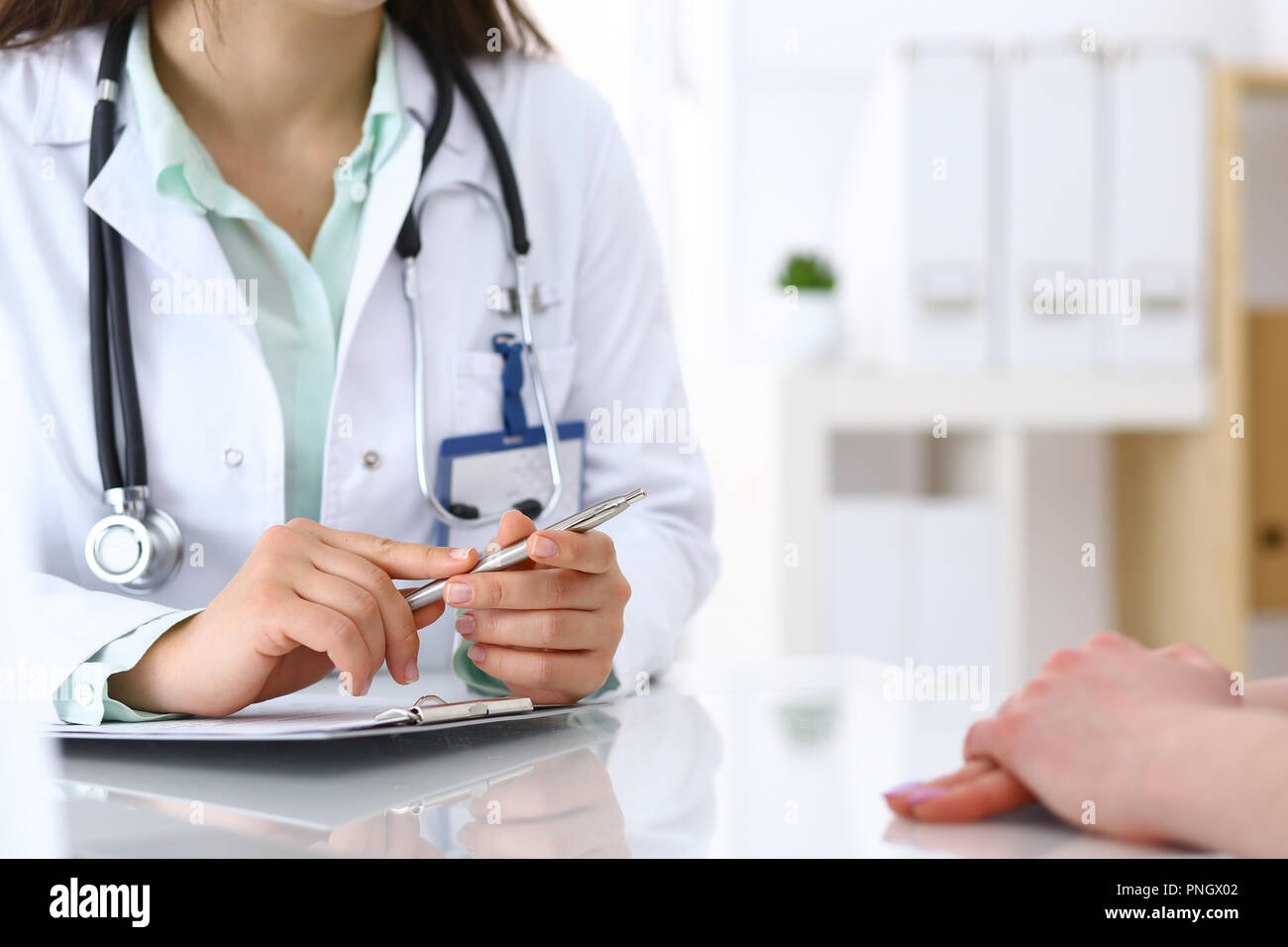 Doctor woman consulting patient while filling up an application form at ...