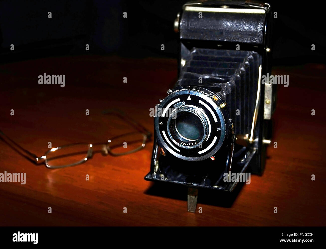 Vintage old photographic camera and glasses. Spot lighting, black ...