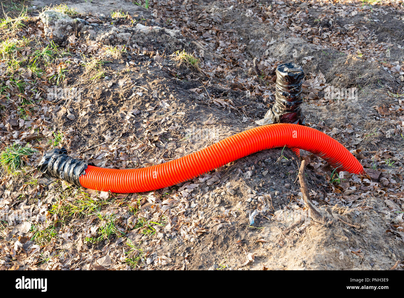 Red orange corrugated sheath for electric cables, on a building ...