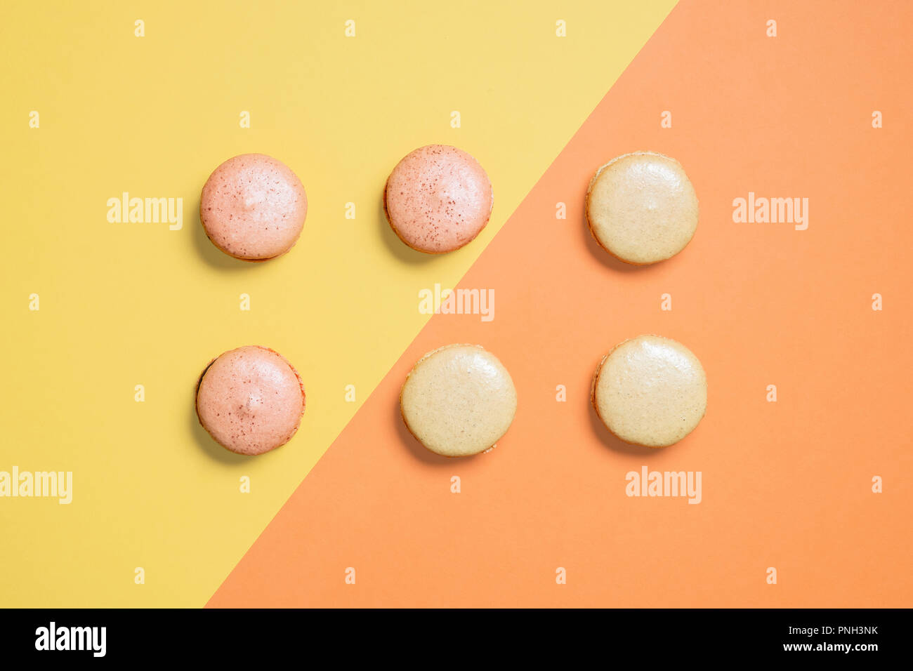Orange and yellow macarons on an angled complimentary split background ...