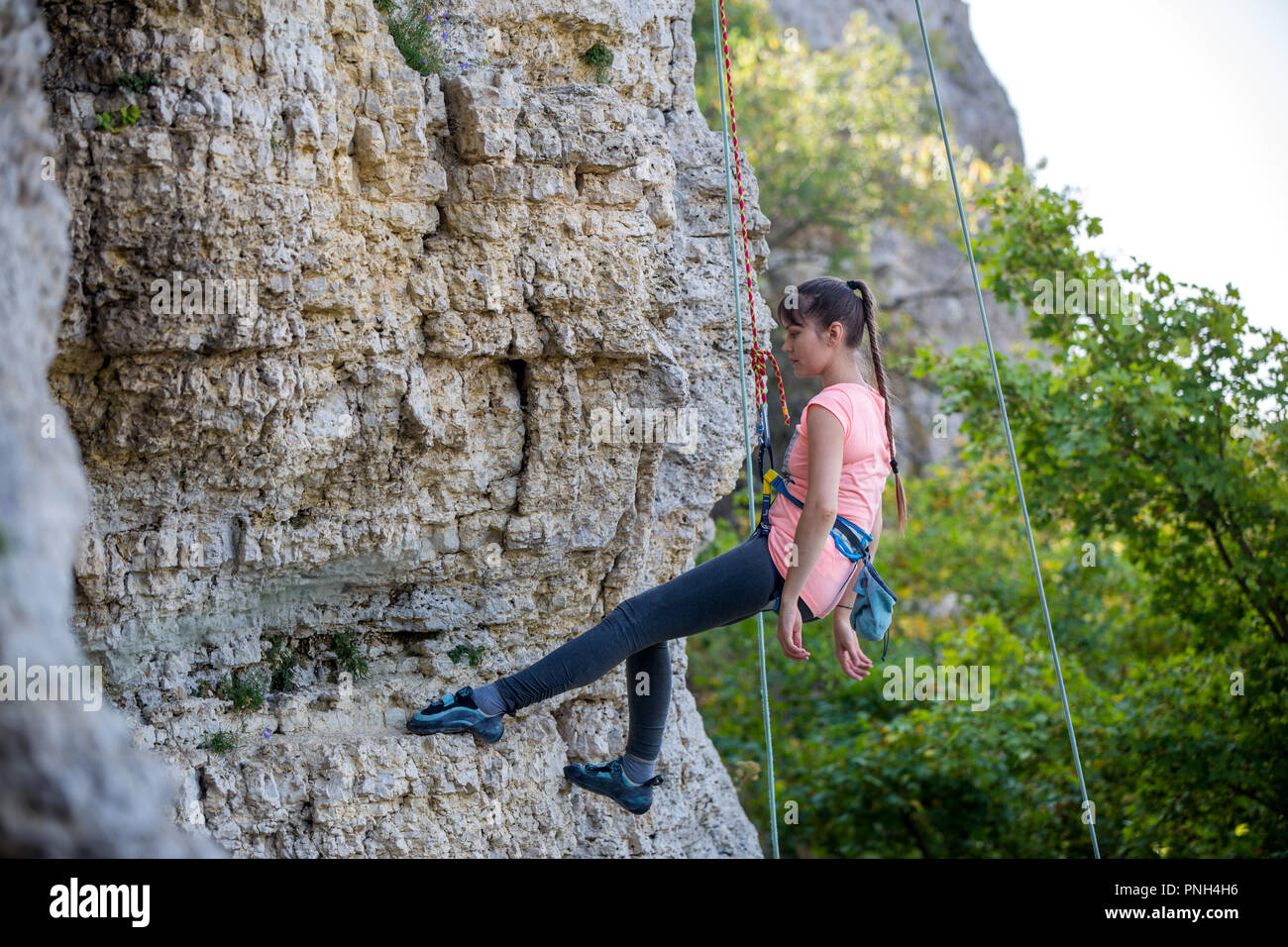 Photo of athlete girl clambering over rock Stock Photo - Alamy