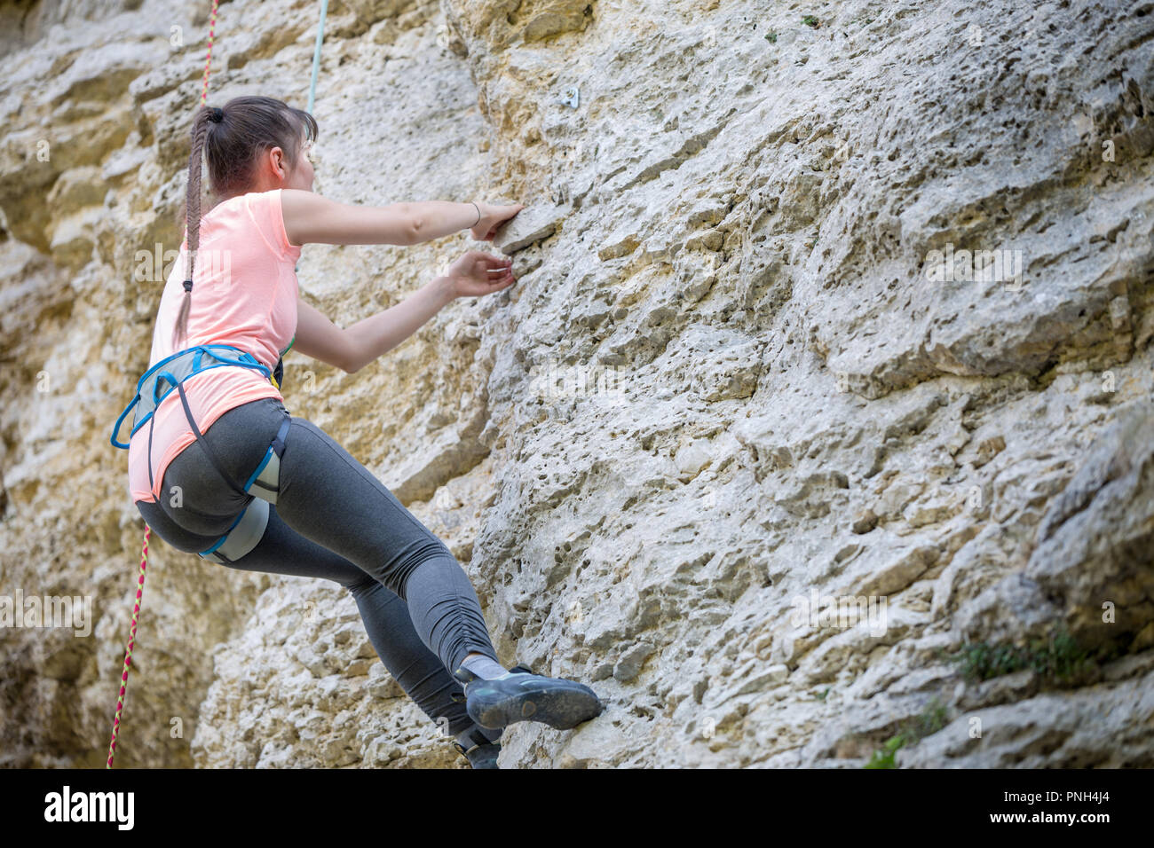Photo of athlete girl clambering over rock Stock Photo - Alamy