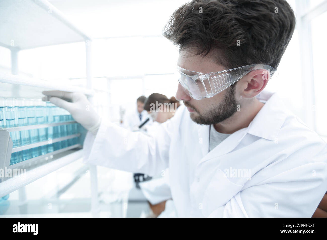 side view of focused scientist holding test tube in laboratory Stock ...