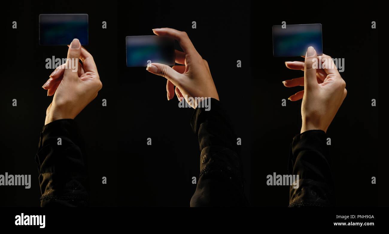 Three female hands holding credit Cards, top lit on black background ...