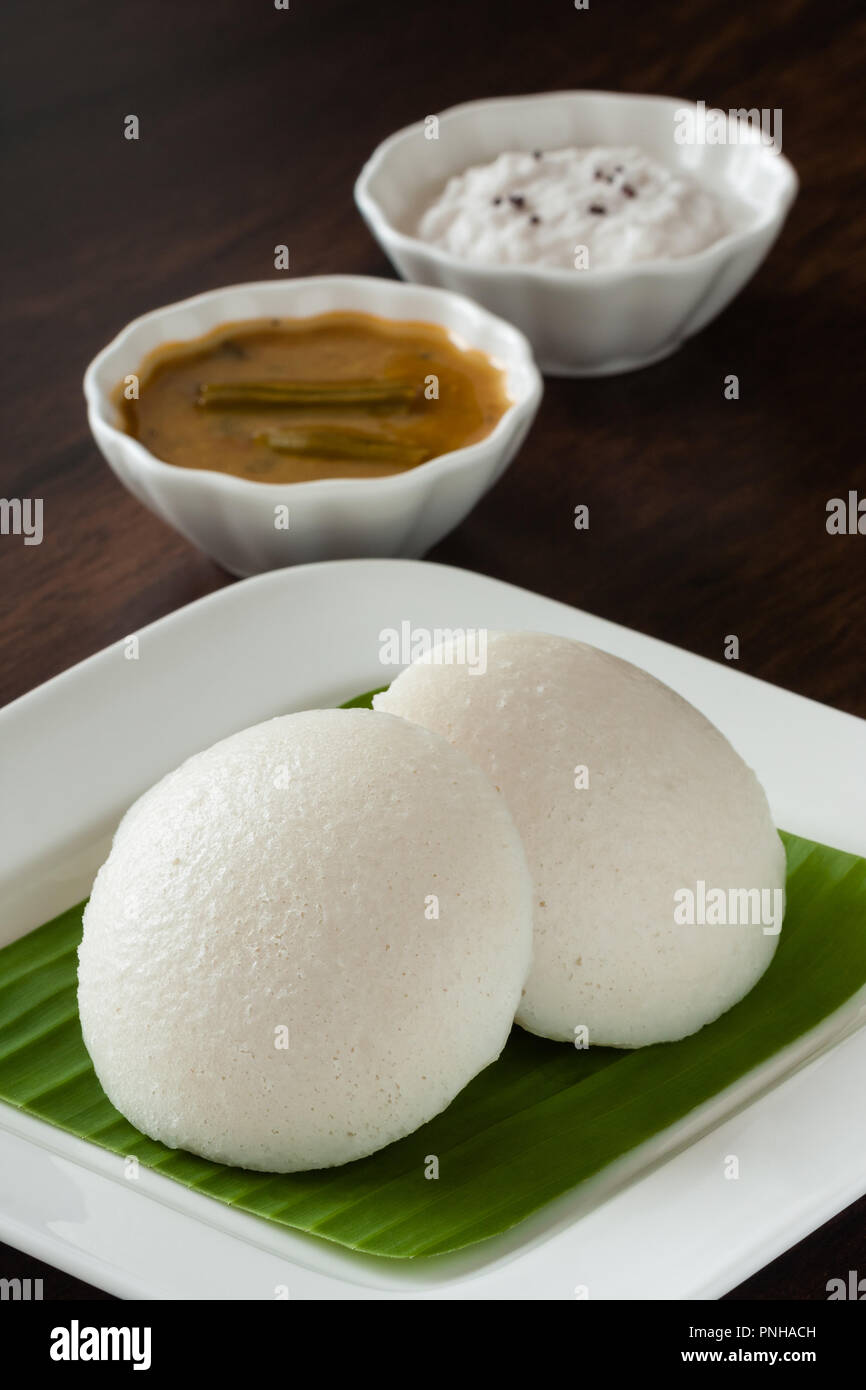 Fresh steamed Indian Idly (Idli / rice cake) arranged on banana leaf ...