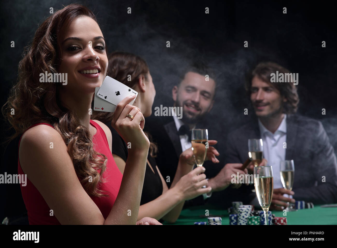 young brunette woman playing poker on black background Stock Photo - Alamy