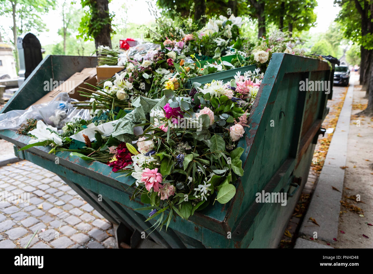 A dumpster filled with discarded flower arrangements that were left ...