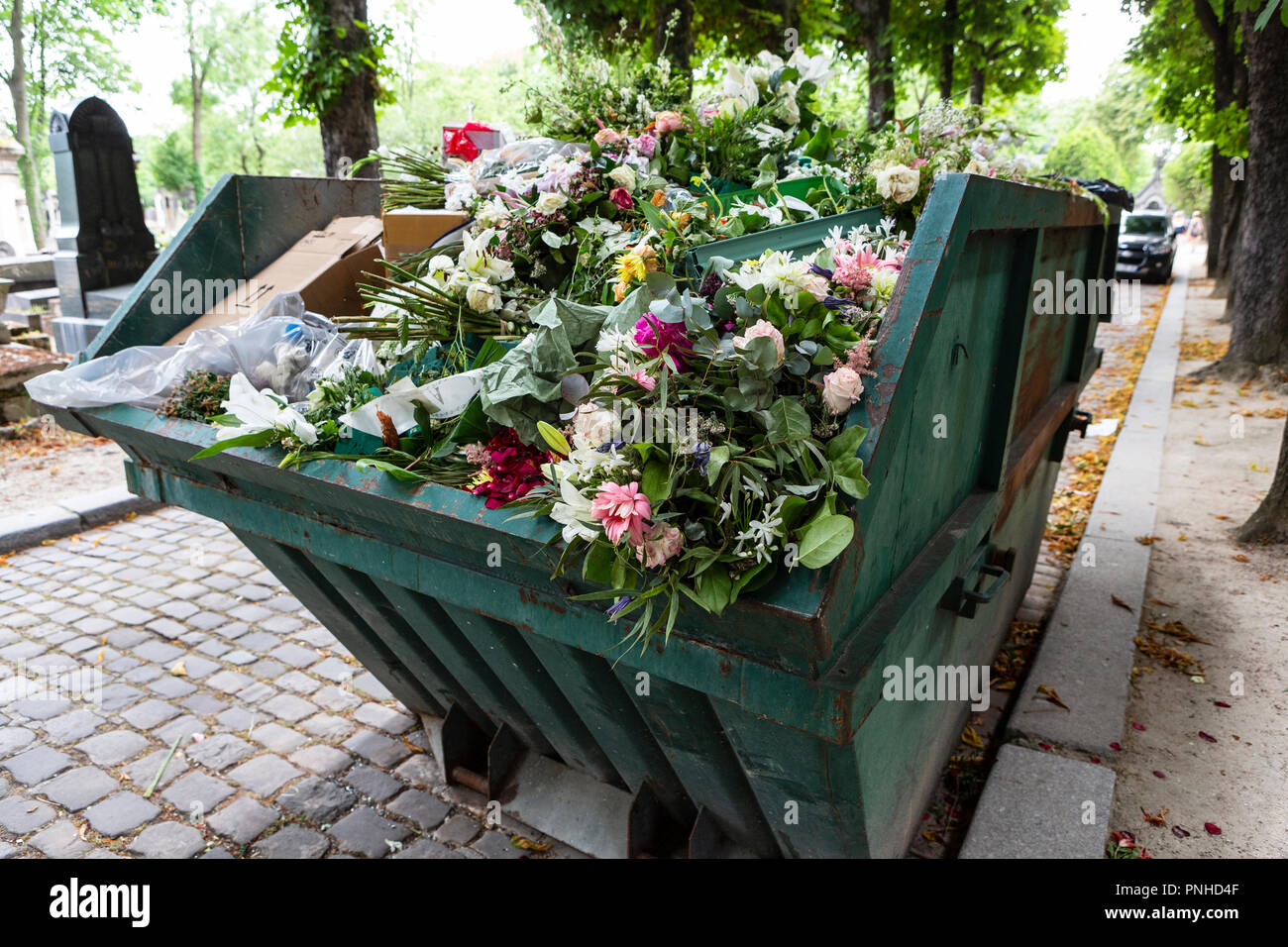 A dumpster filled with discarded flower arrangements that were left ...