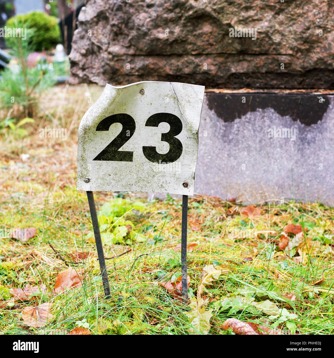 Tin plate with a number 23 sticked into the ground Stock Photo - Alamy