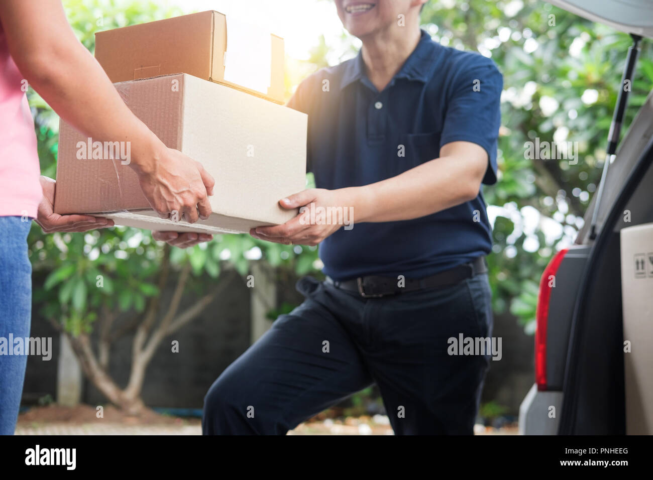 Woman receiving parcel cardboard box from delivery man Carrying Courier ...