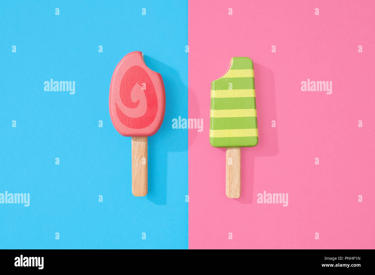 Assorted wooden toy ice lollipop popsicles on a split coloured pastel ...
