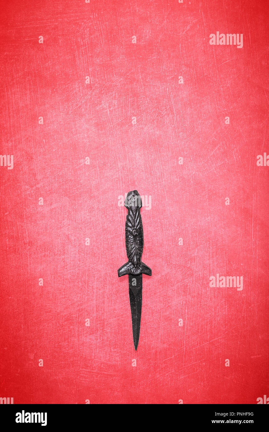 Black Wicca wiccan dagger on a textured red background with space for ...