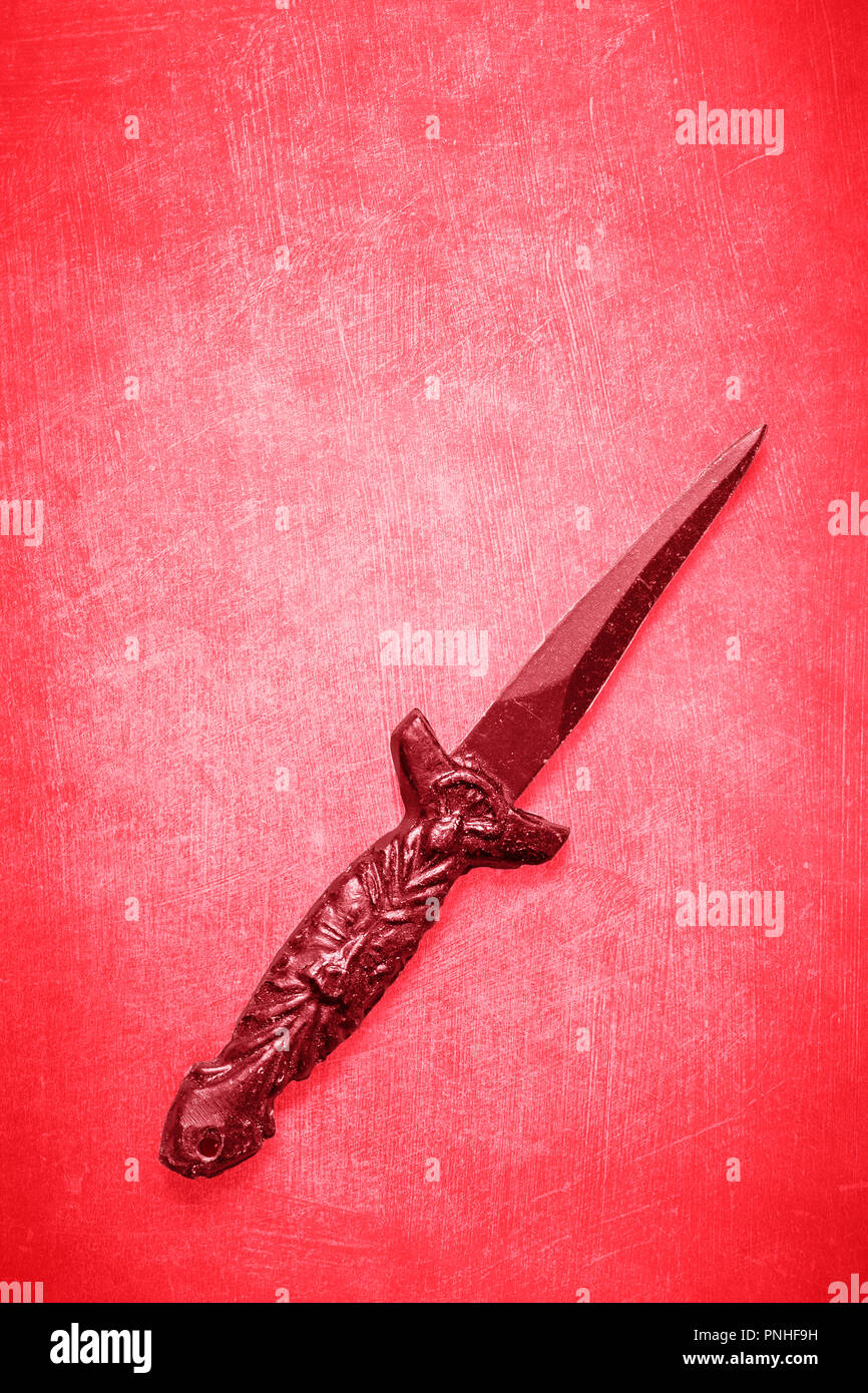 Red Wicca wiccan dagger on a red textured background with space for ...