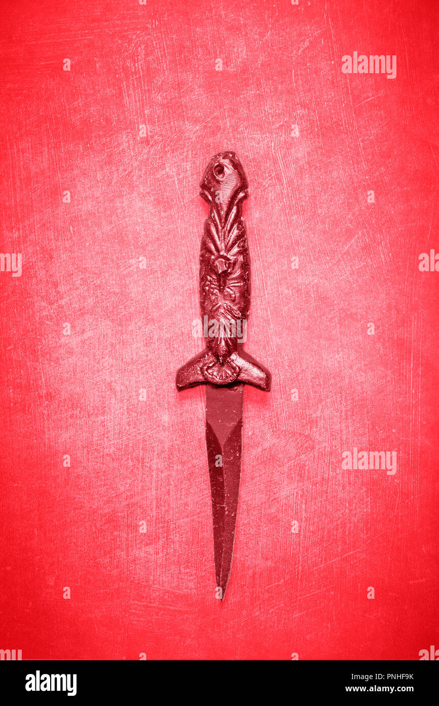 Red Wicca wiccan dagger on a red textured background with space for ...